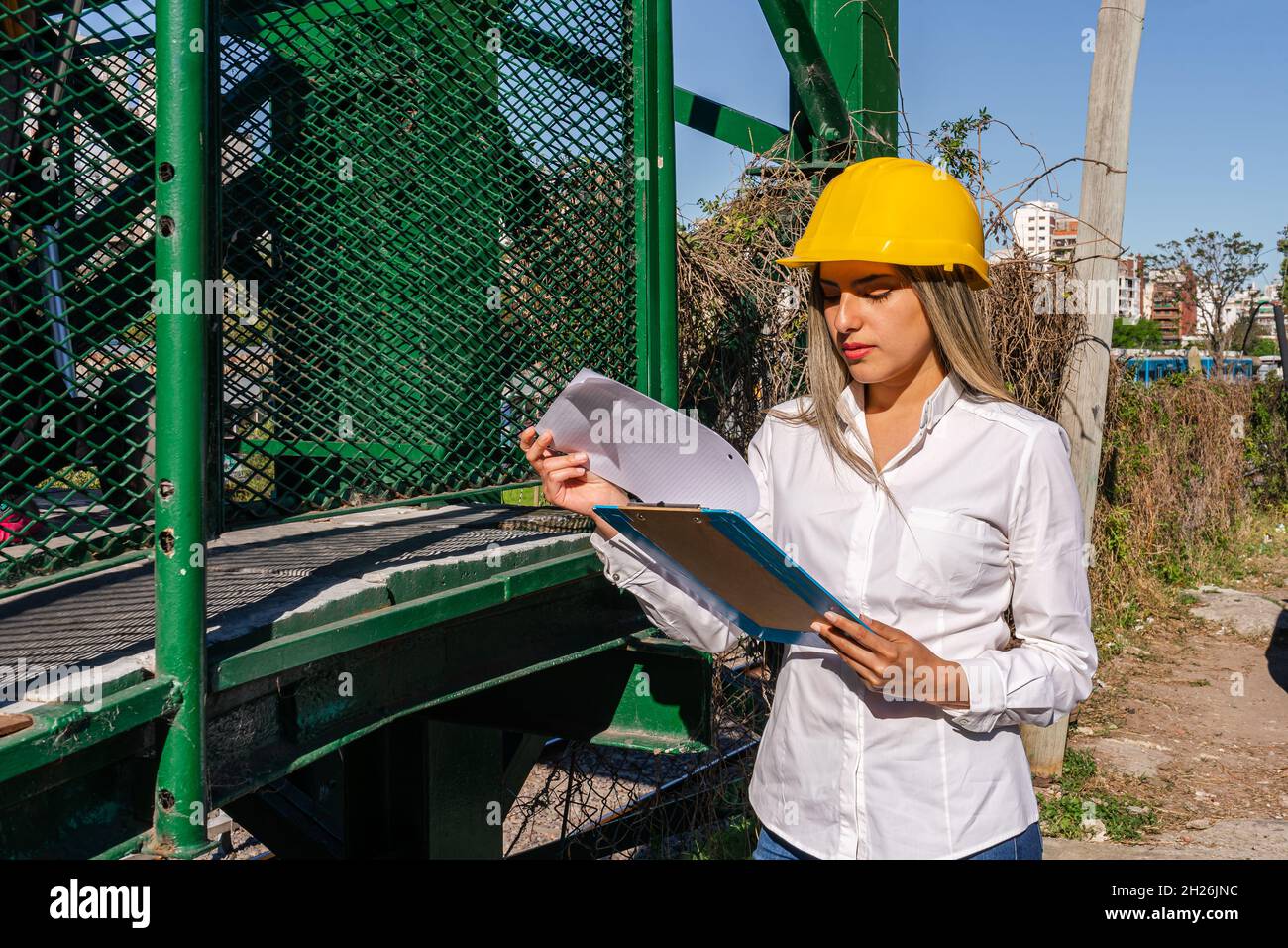 Beautiful young female engineer or supervisor, wearing safety helmet ...