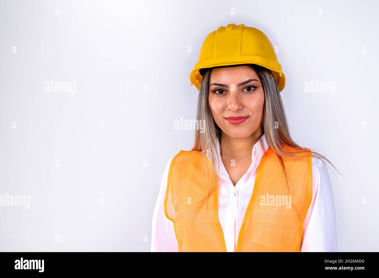 Beautiful young female engineer or supervisor, wearing safety equipment ...