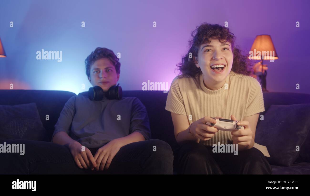 Beautiful curly-haired gamer girl beat her boyfriend on a video game ...