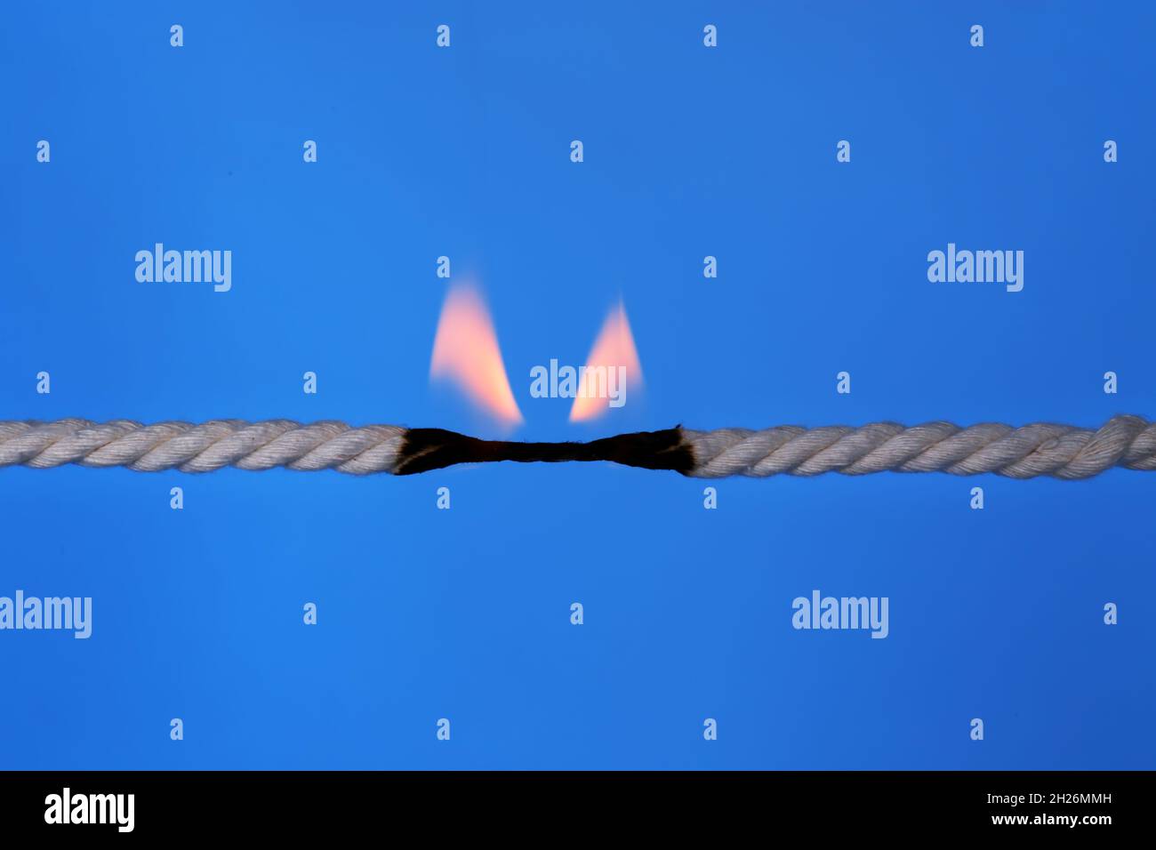 Burning rope at breaking point on color background Stock Photo - Alamy