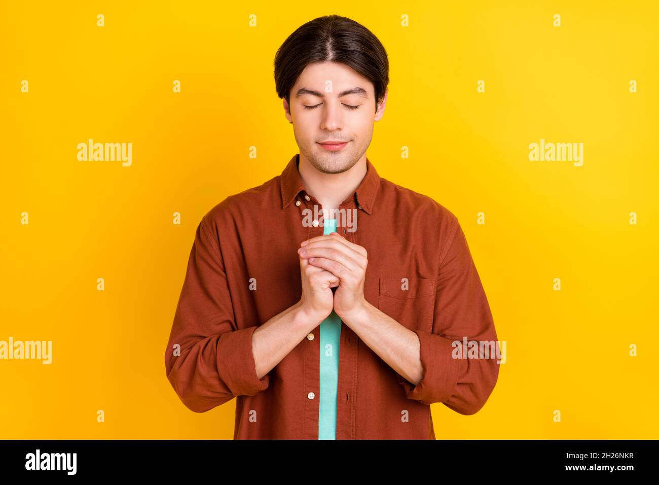 Photo of dreamy charming young man wear brown shirt arms together ...