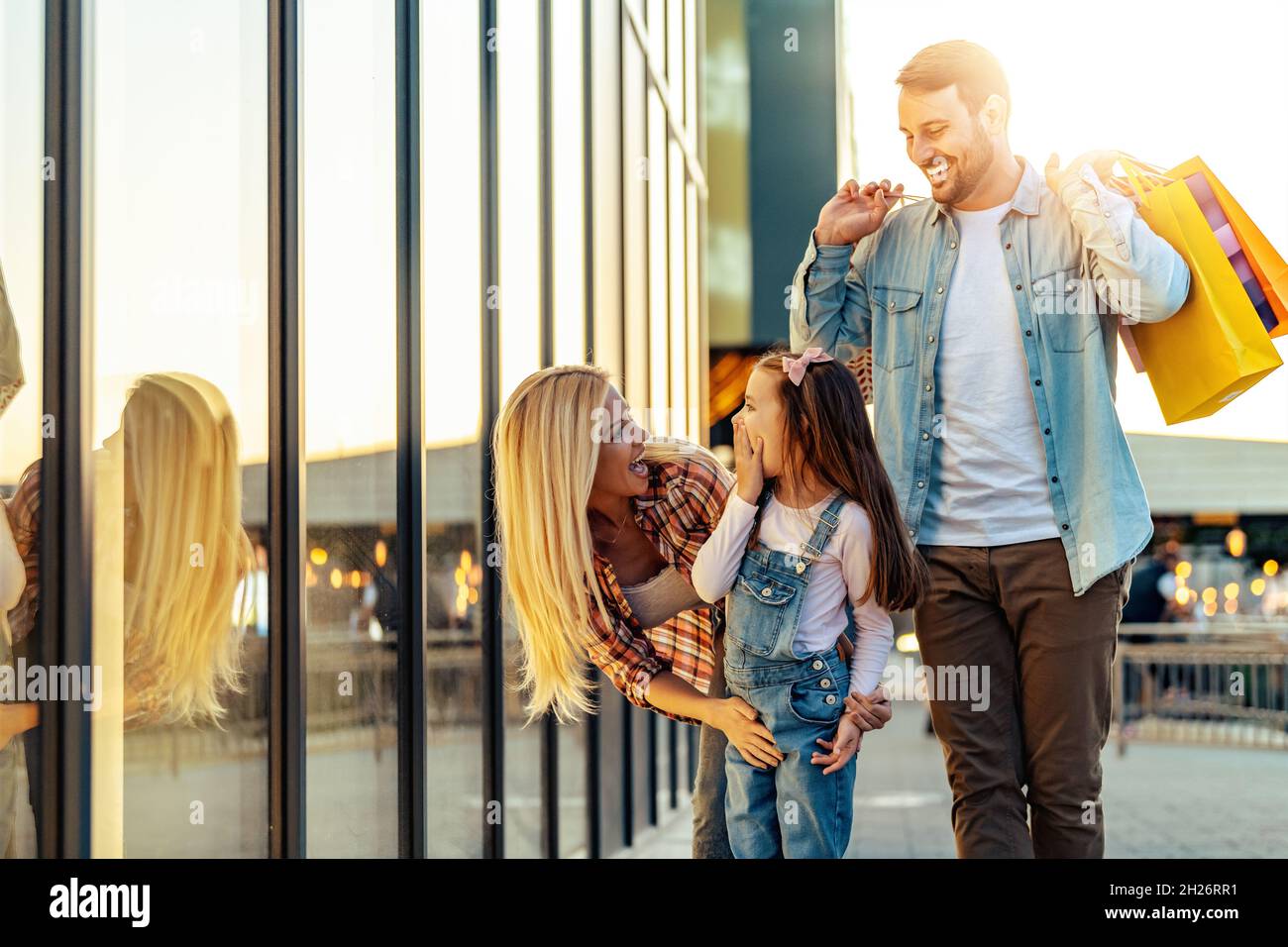 Family shopping in the city. Parents and their daughter are holding ...