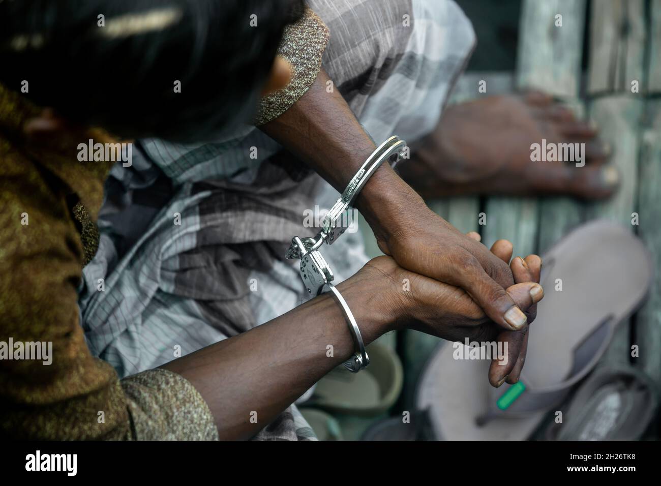 Handcuffs on the hands of the accused. The policeman puts handcuffs on ...