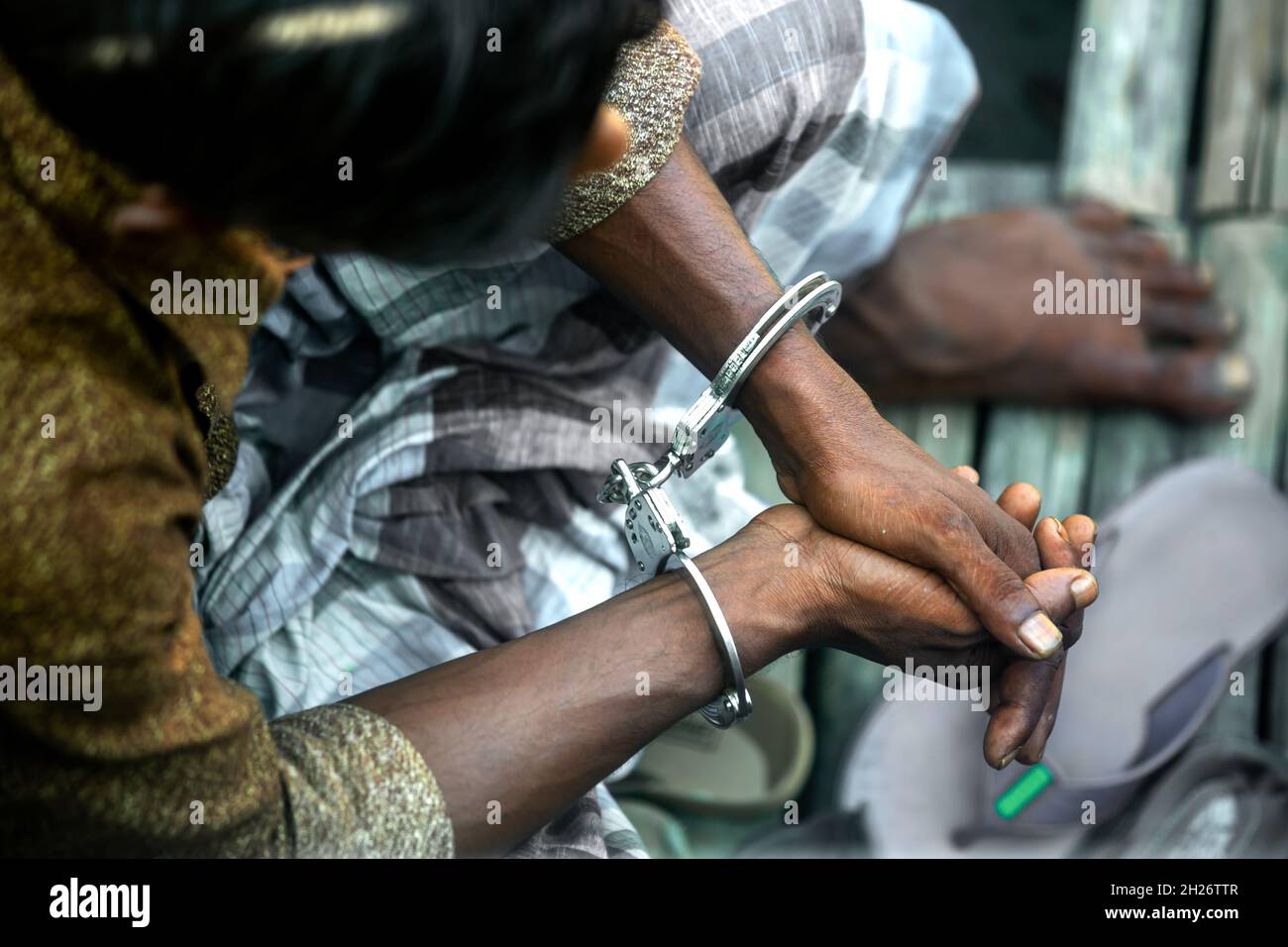 Handcuffs on the hands of the accused. The policeman puts handcuffs on ...