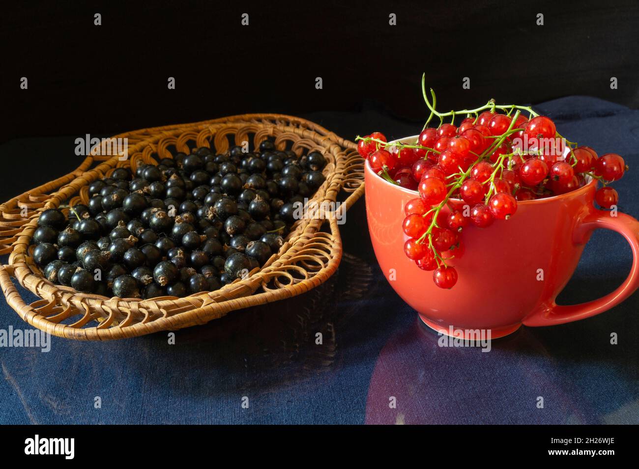 Still life with red and black currants on the table. Food products on a ...
