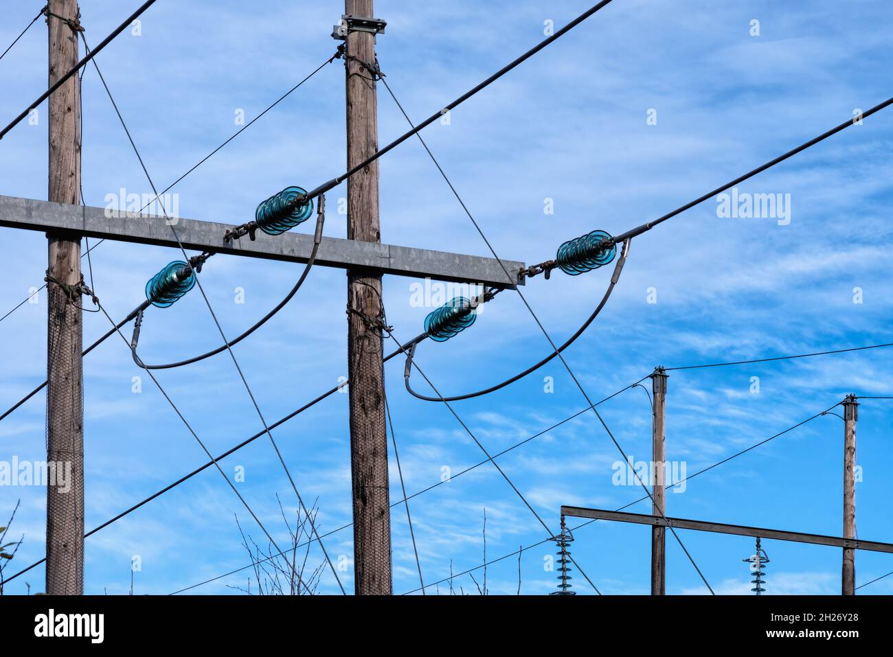 Power supply line with three wires mounted on old wooden pillar, blue ...