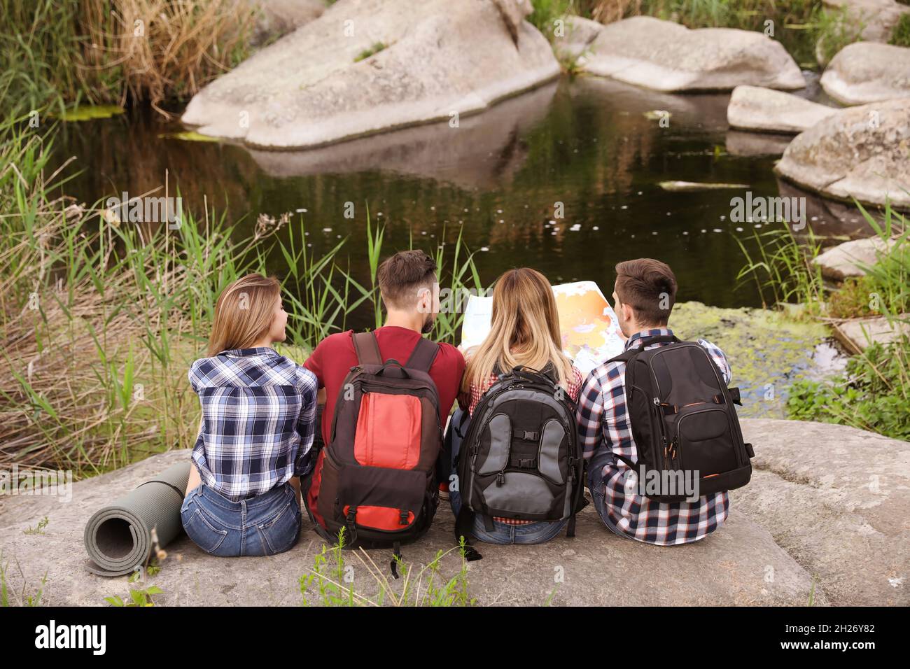 Young people exploring map in wilderness. Camping season Stock Photo ...