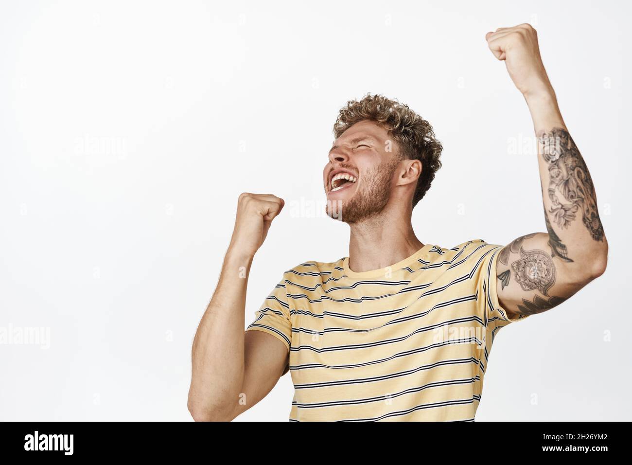 Victory and celebration. Young blond male model, fan celebrating ...