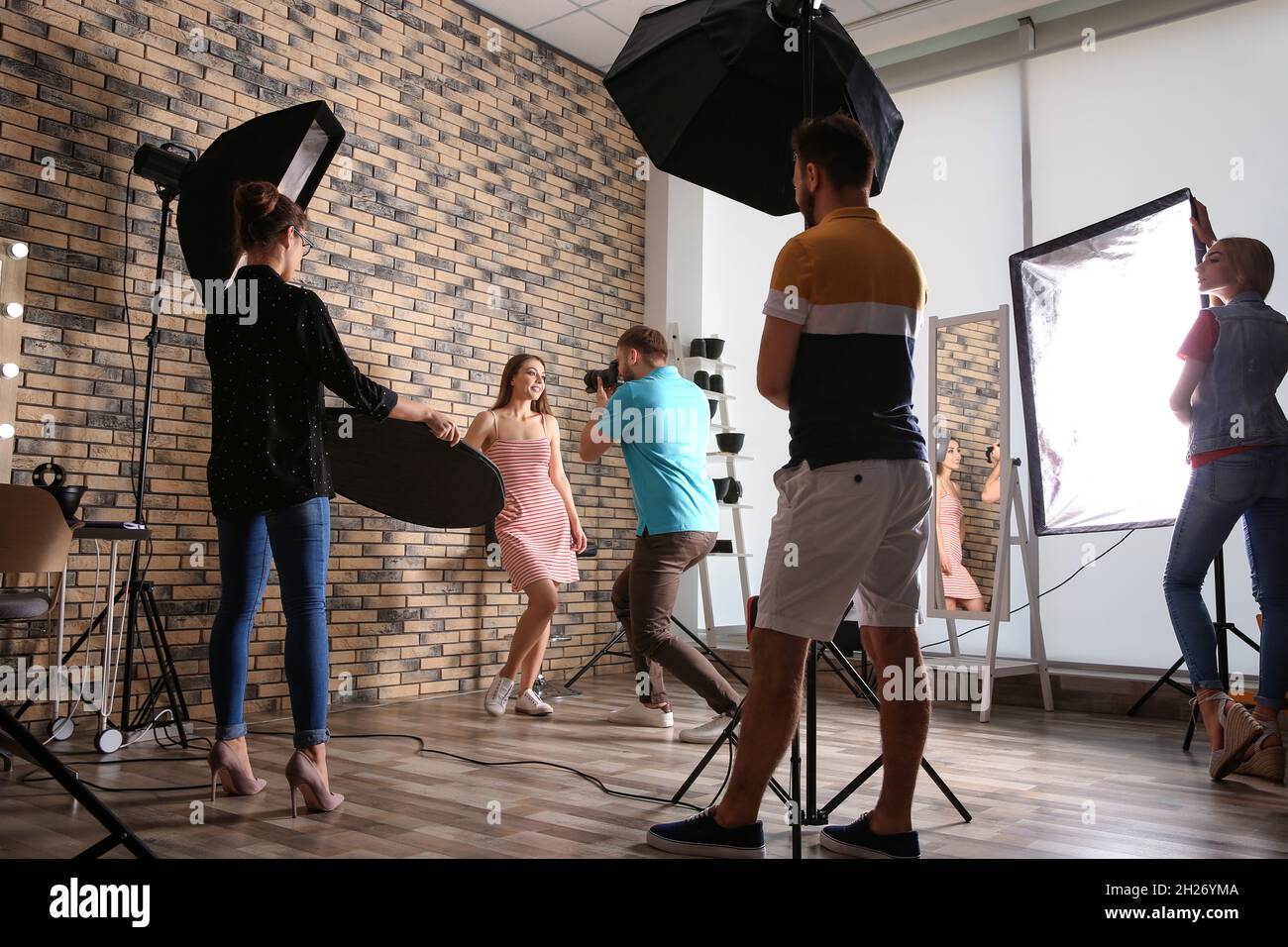 Professional team working with model in photo studio Stock Photo - Alamy