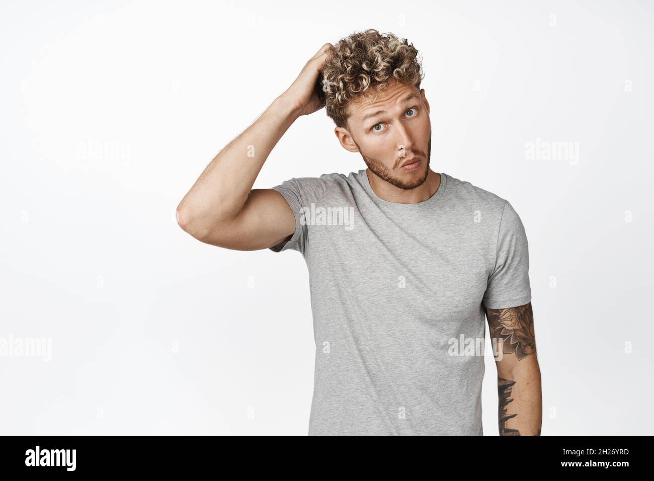 Dumb guy scratching head and looking confused, staring puzzled and has ...