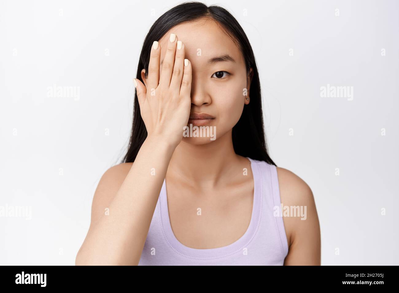 Beauty and skin care. Smiling asian girl cover half of face and looking ...