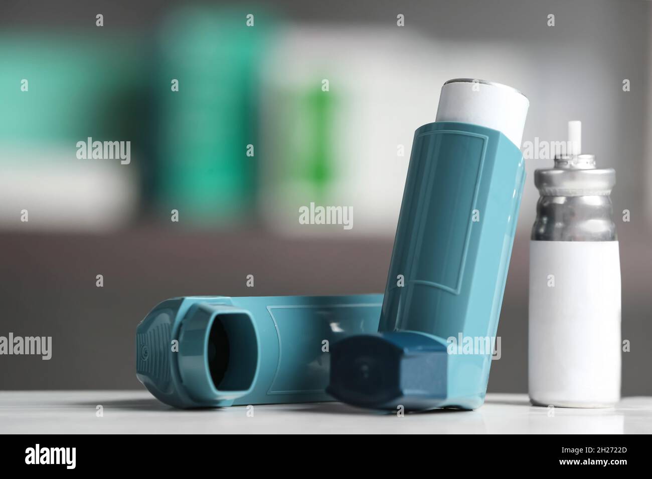 Asthma inhalers on table against blurred background. Space for text ...