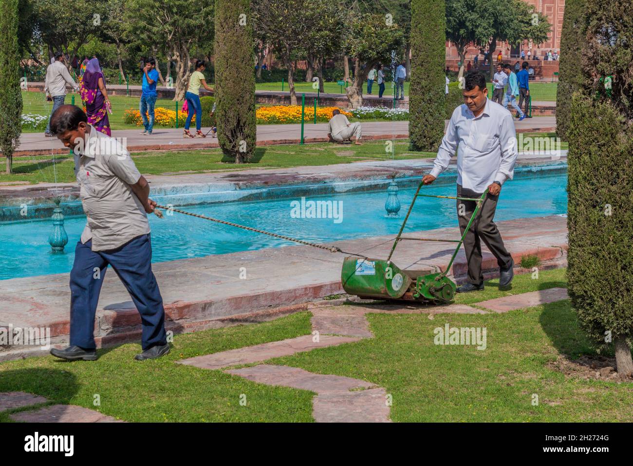 AGRA, INDIA - FEBRUARY 19, 2017: Workers are mowing a lawn Taj Mahal ...