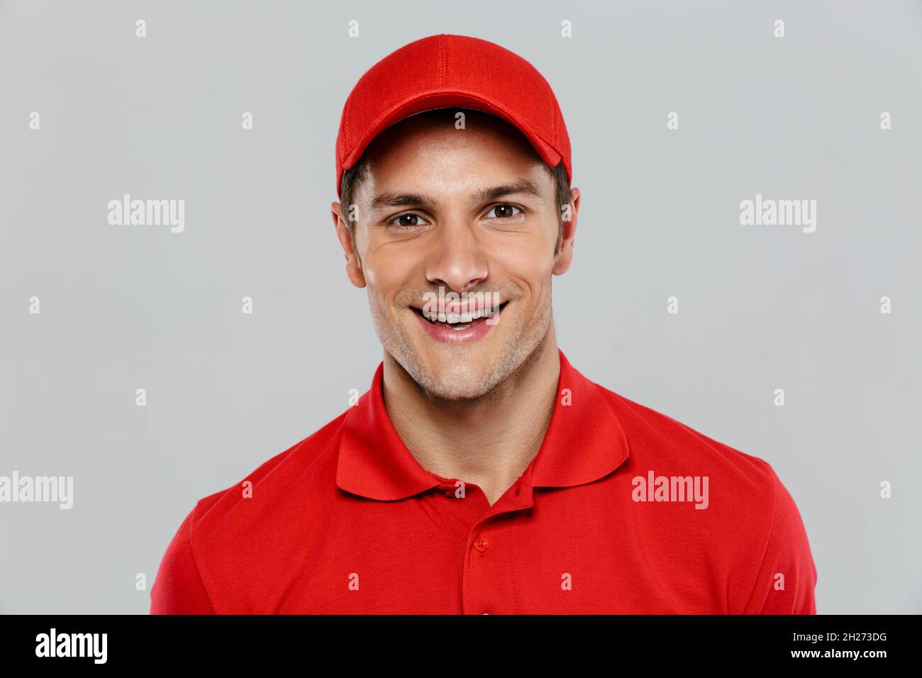 Young Delivery Man Wearing Uniform Smiling And Looking At Camera
