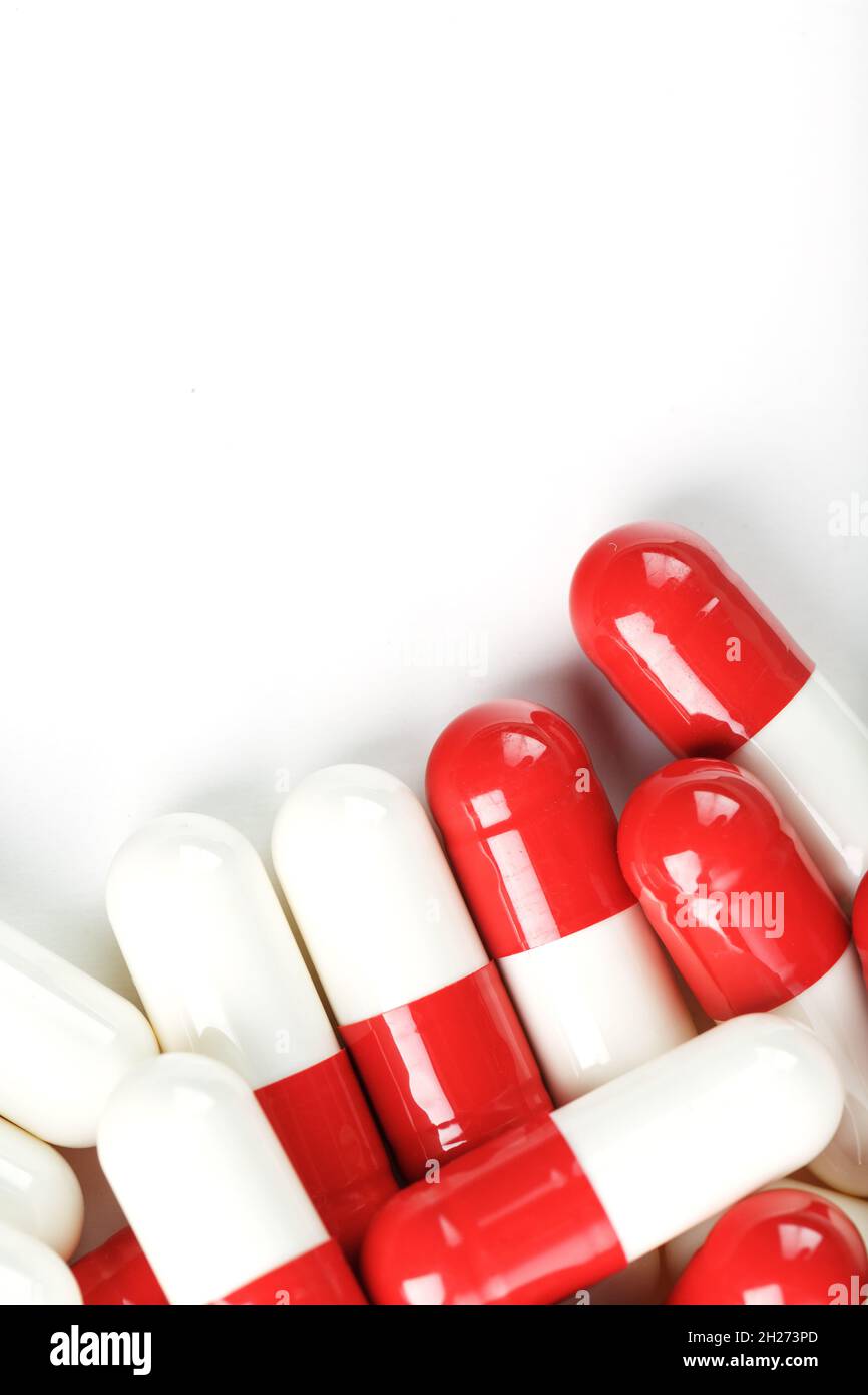 Red and white tablets on a white background with free space. Top view ...