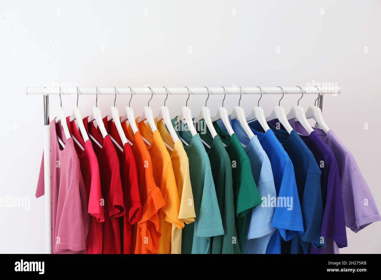 Rack with bright clothes on white background. Rainbow colors Stock ...