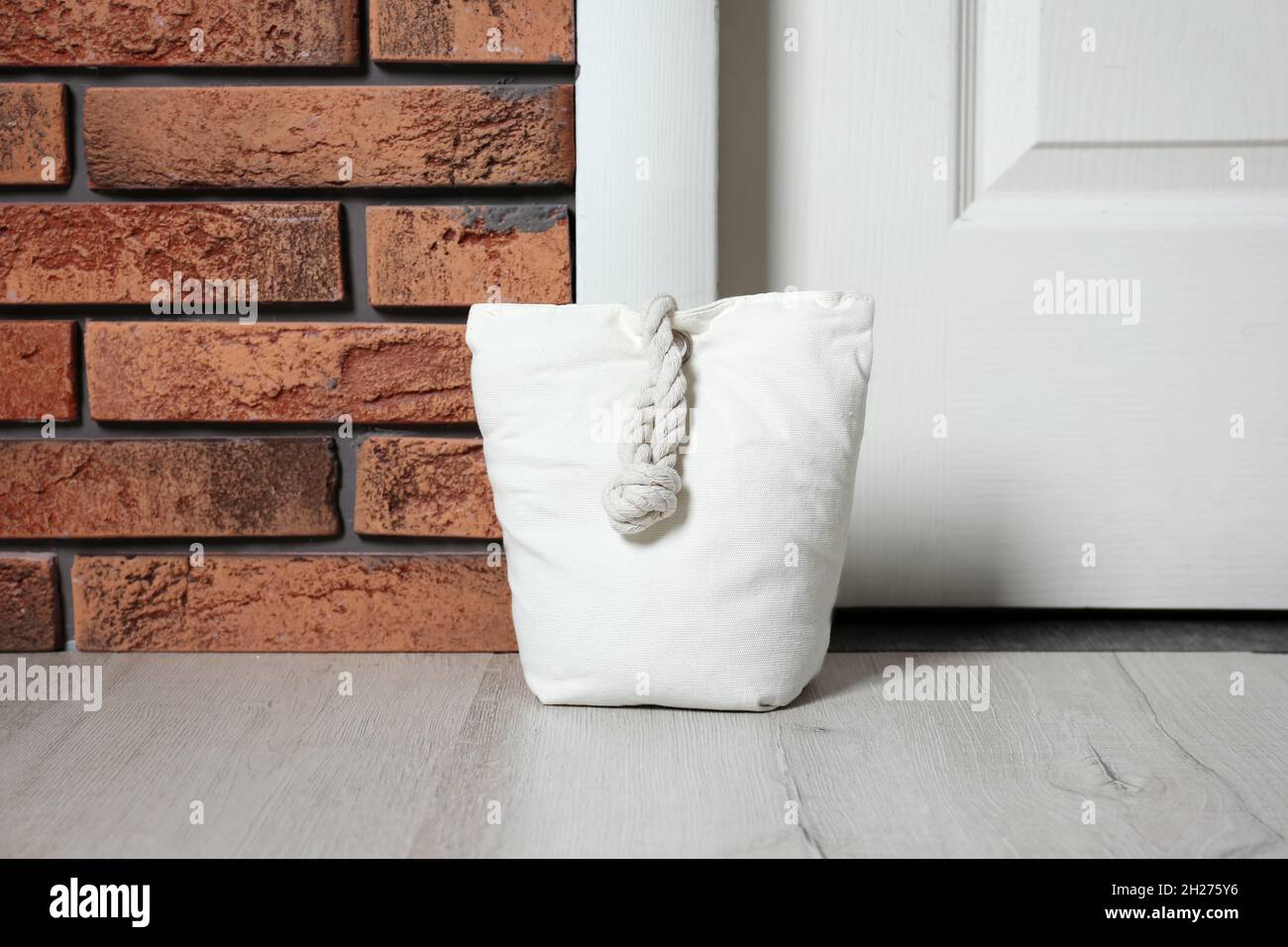 Stuffed bag near white door at home Stock Photo - Alamy