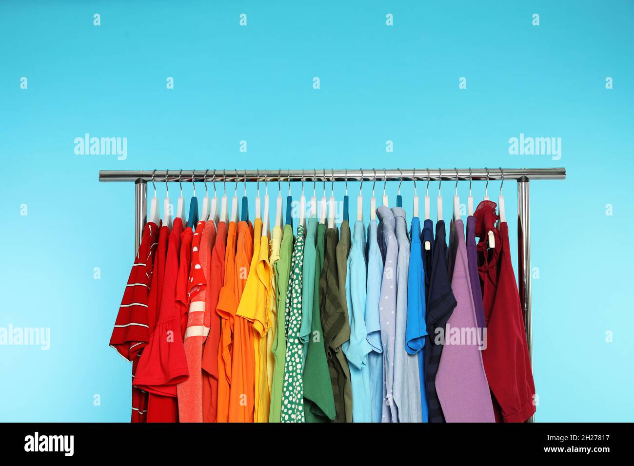 Wardrobe rack with different bright clothes on color background Stock ...