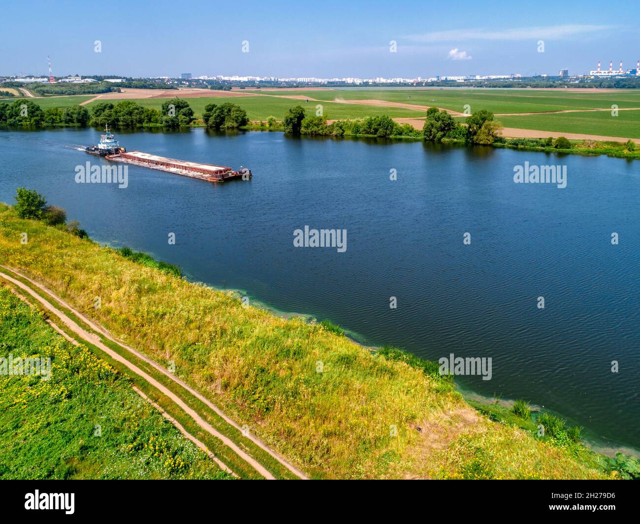 A cargo barge floats on a small river Stock Photo - Alamy