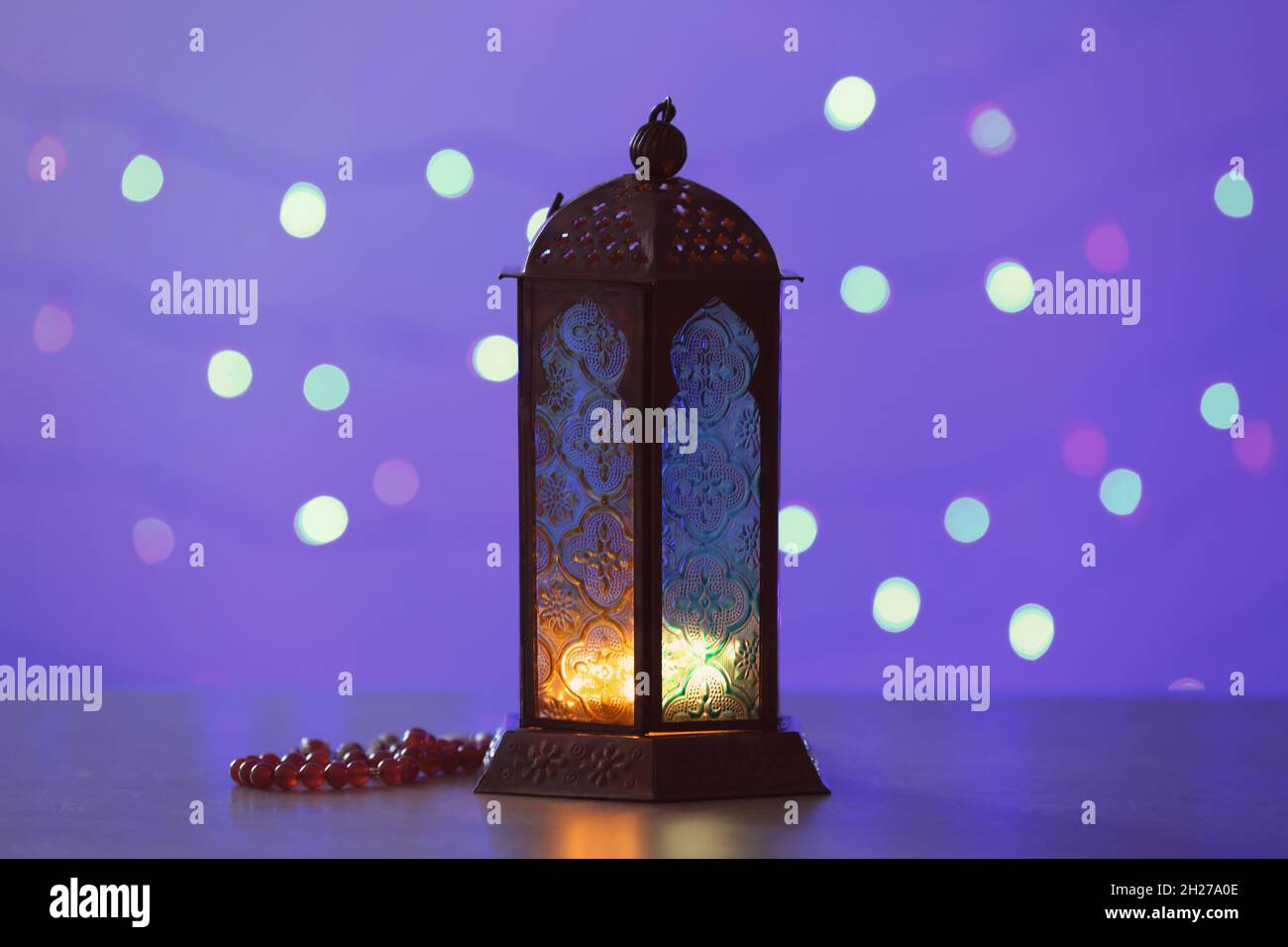 Muslim lamp Fanus with prayer beads on blurred lights background Stock ...