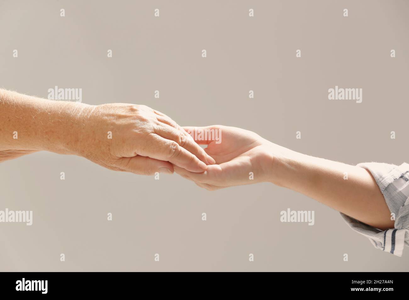 Helping hands on gray background, closeup. Elderly care concept Stock ...