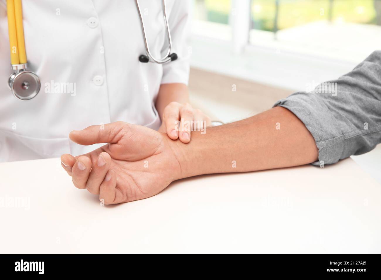 Doctor checking senior man's pulse in hospital Stock Photo - Alamy
