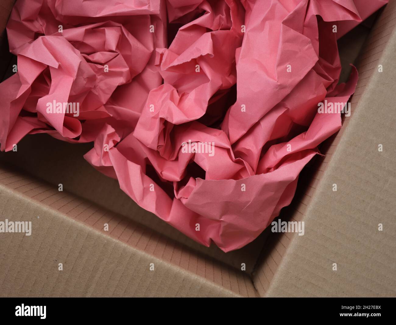 Crumpled pink paper in a cardboard box. Close up Stock Photo - Alamy
