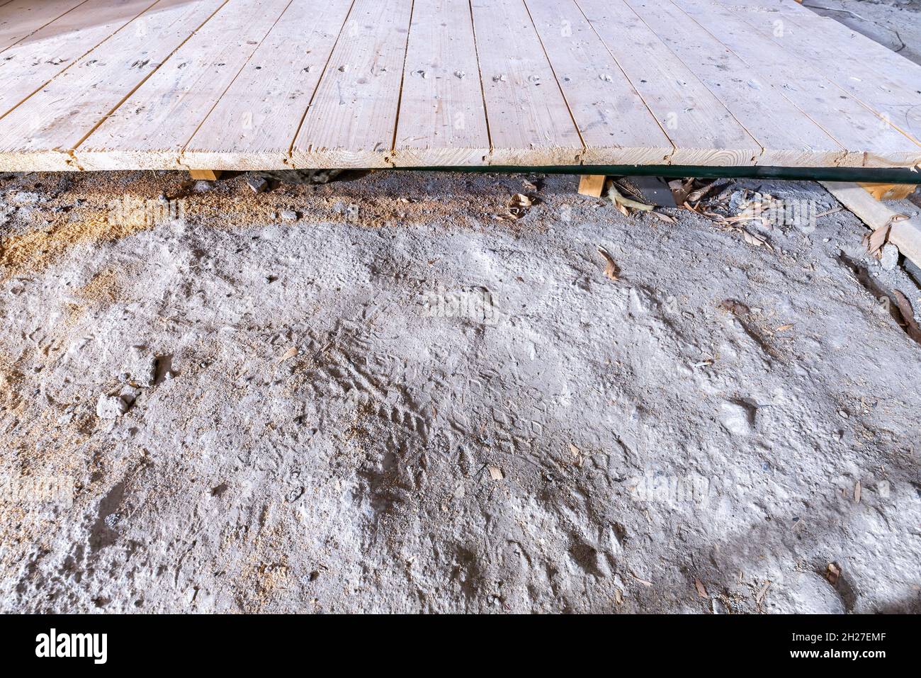 Partly cut down old wooden floor on concrete basement floor in ...