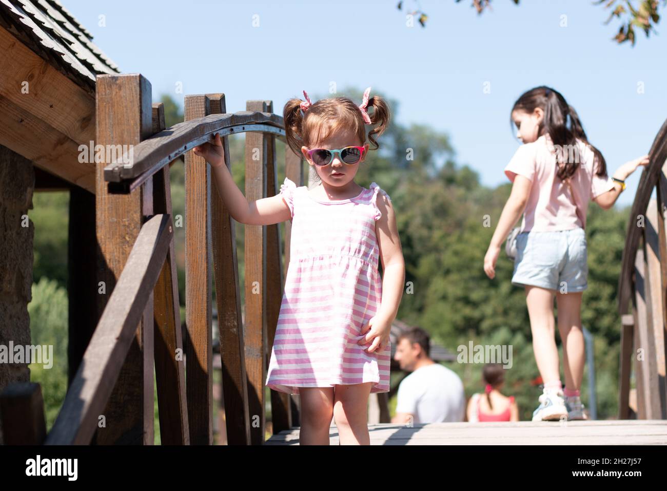 Little sad beautiful red-haired girl with pigtails, holding on to the ...