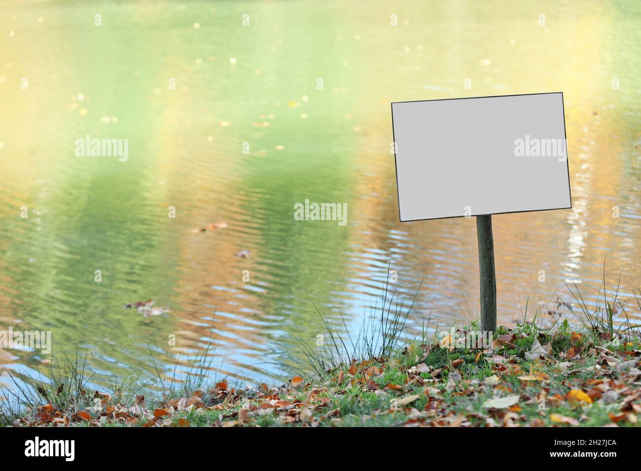 Empty sign board near pond. Space for text Stock Photo - Alamy