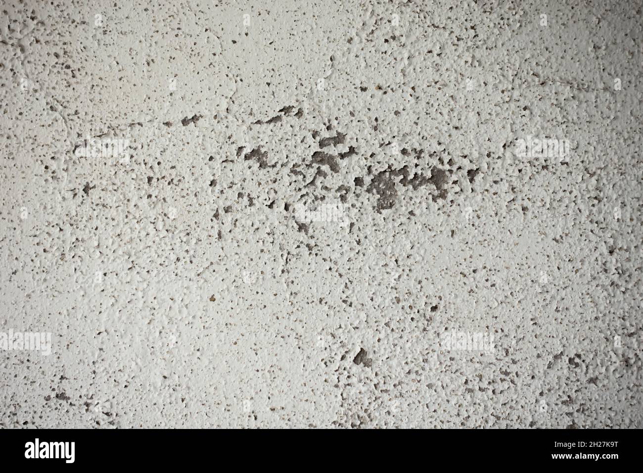 White damp wall showing paint cracking open and breaking or peeling off ...