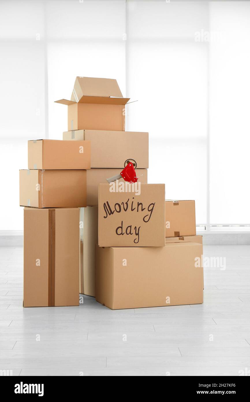 Pile of moving boxes in empty room Stock Photo - Alamy