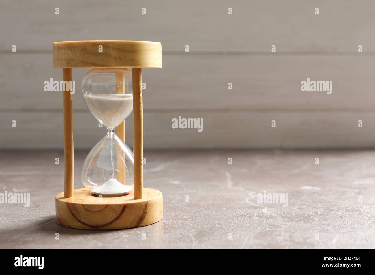 Hourglass with flowing sand on table. Time management Stock Photo - Alamy