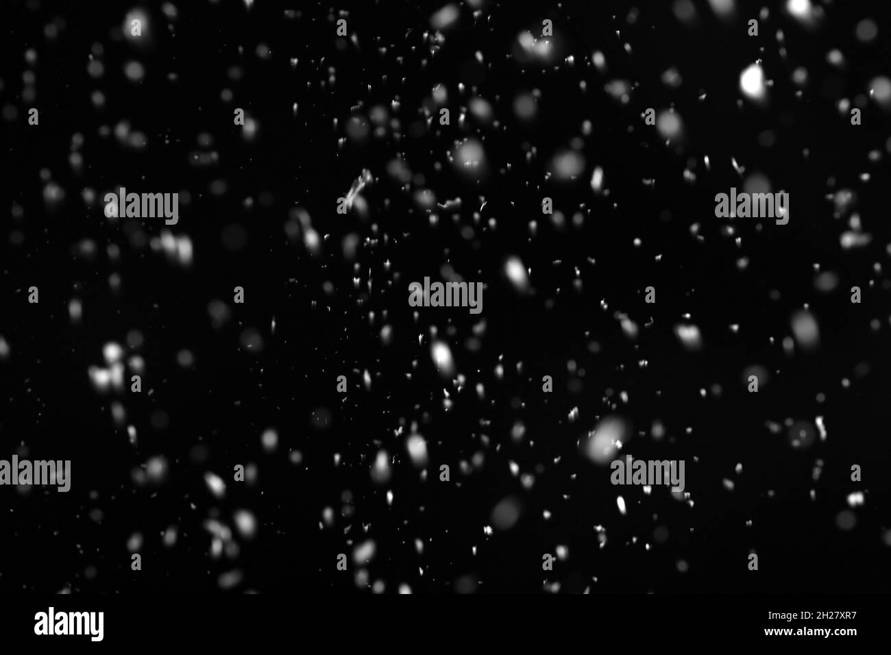 Snow flakes falling on black background. Winter weather Stock Photo - Alamy