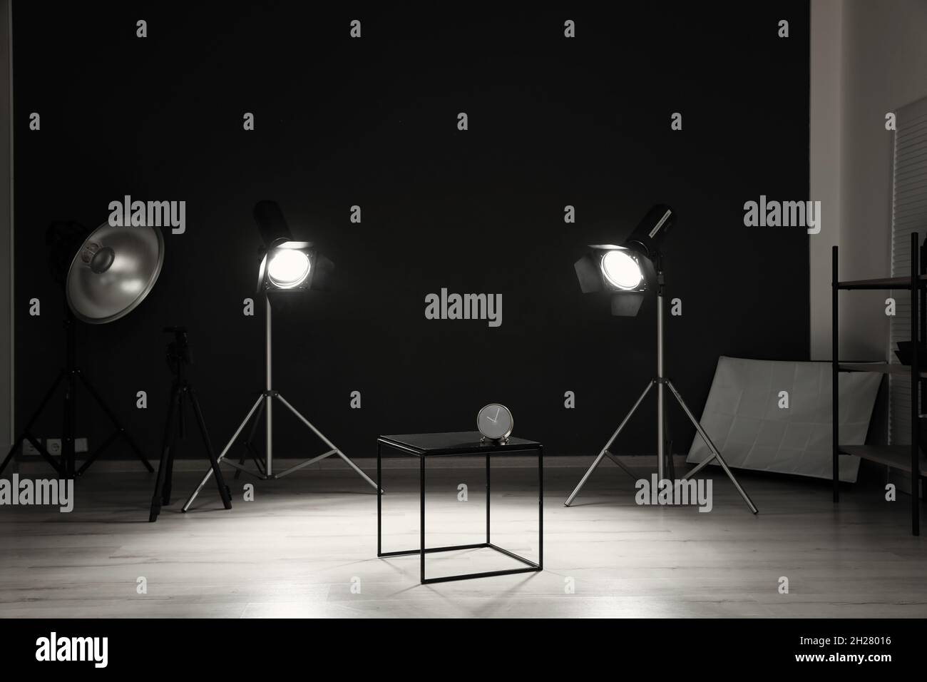 Interior of modern photo studio with table, clock and professional ...
