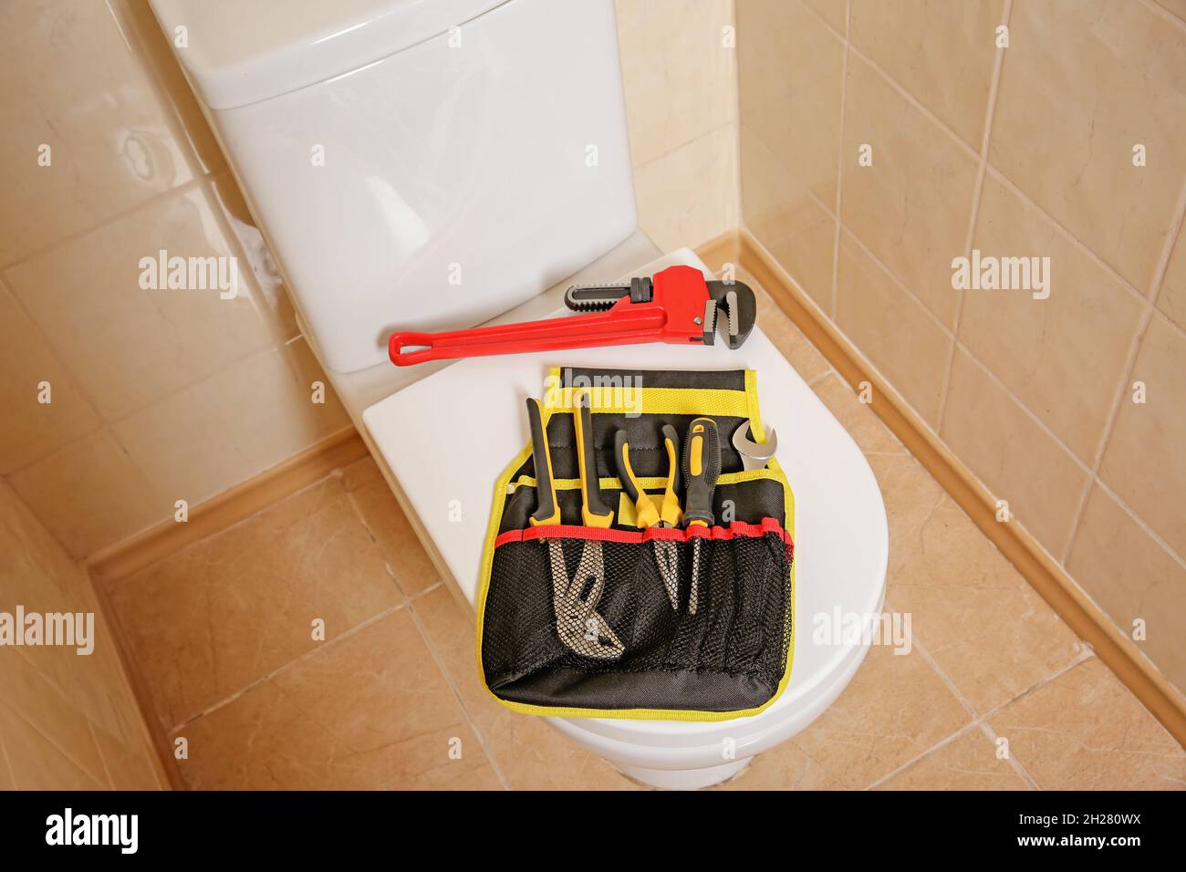 Different plumber's tools on toilet seat lid indoors Stock Photo - Alamy
