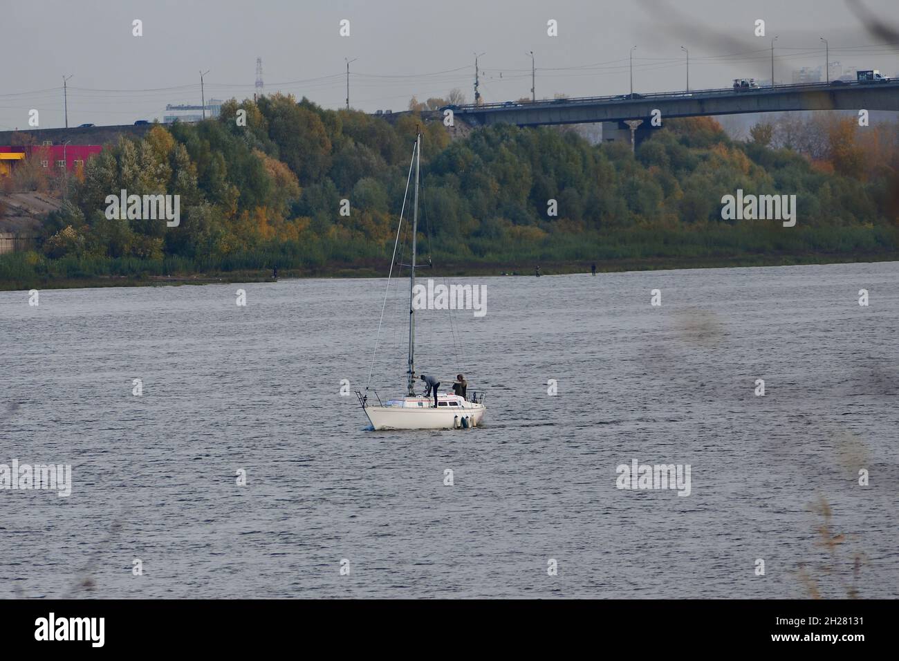 Sailing yacht on the river. A yacht without a sail goes along the river ...