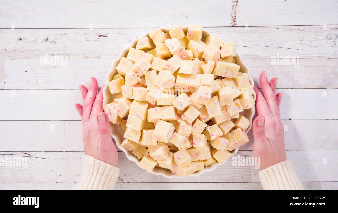 Flat lay. Step by step. Candy cane fudge cut in small cubes on a white ...