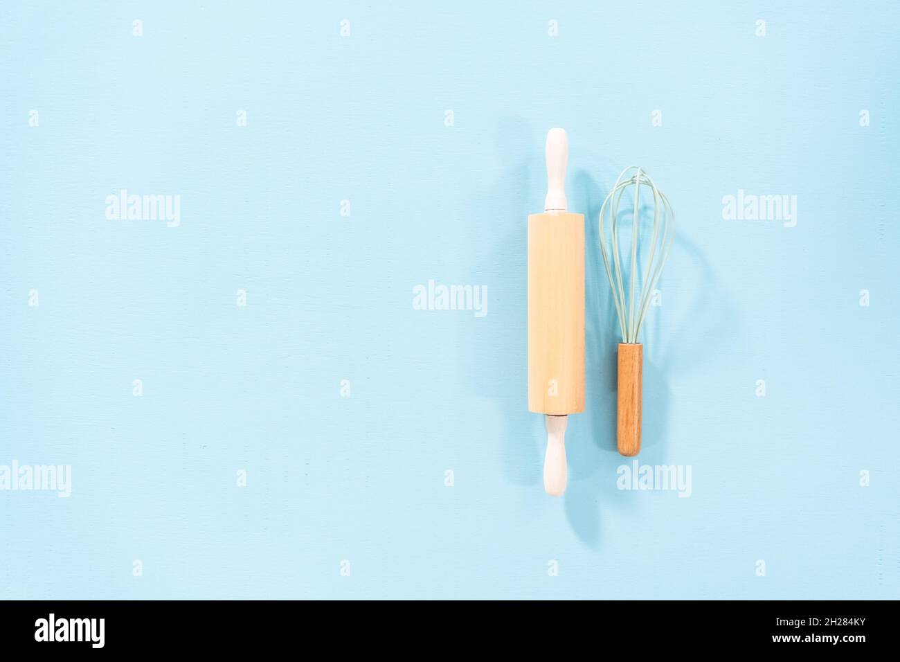 Flat lay. New blue silicone kitchen utensils with wooden handles on a ...