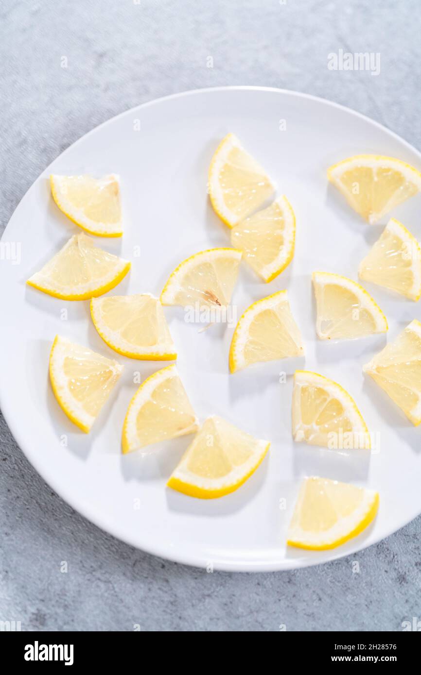 Sliced organic lemon wedges on a white plate Stock Photo - Alamy