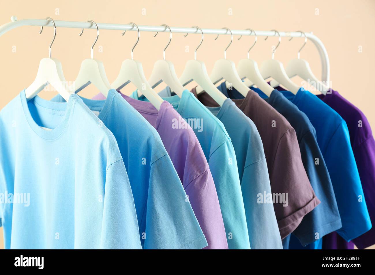 Men's clothes hanging on wardrobe rack against light background Stock ...