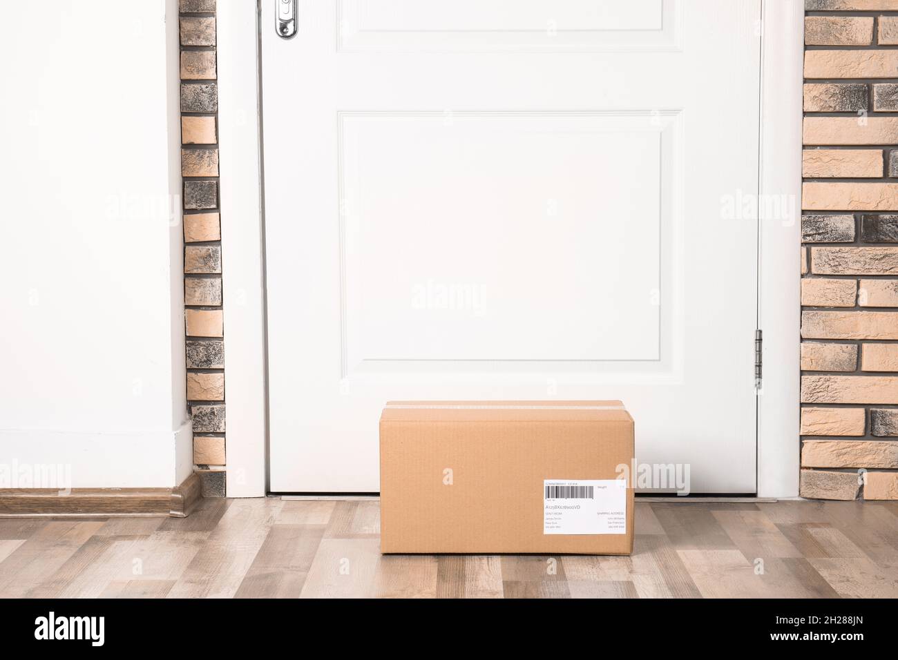 Cardboard parcel box on floor near apartment entrance. Mockup for ...