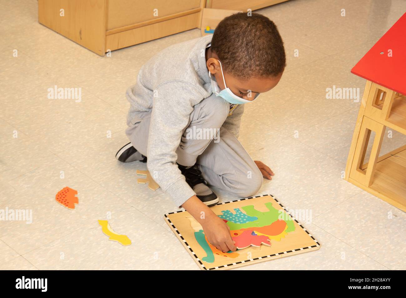 Education Preschool 3-4 year olds boy focused on doing wooden colorful ...