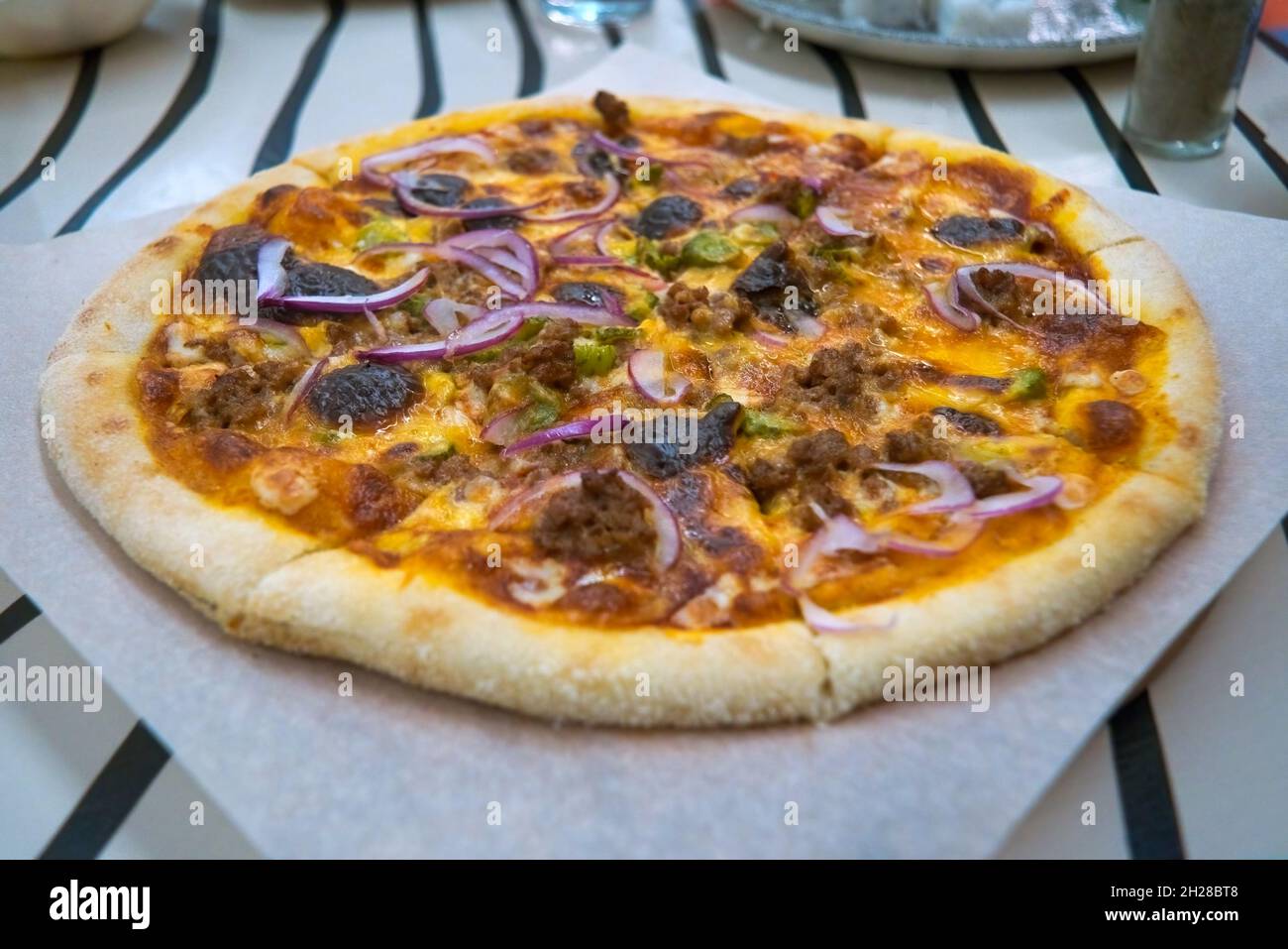 Fresh appetizing pizza with delicious ingredients On a table in a cafe ...