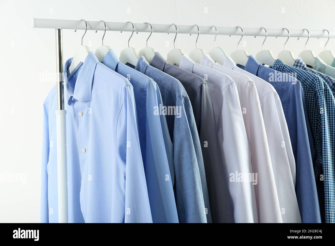 Men's clothes hanging on wardrobe rack against white background Stock ...