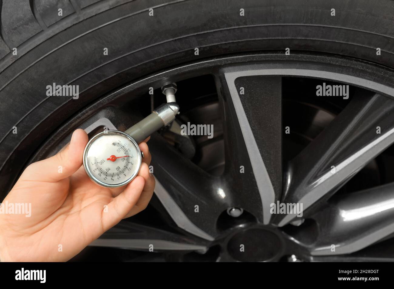 Man measuring car tire pressure with air gauge, closeup. Safety control ...