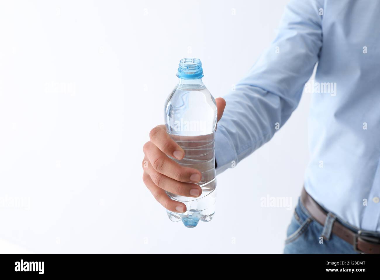 Man holding bottle of pure water on white background, closeup. Space ...
