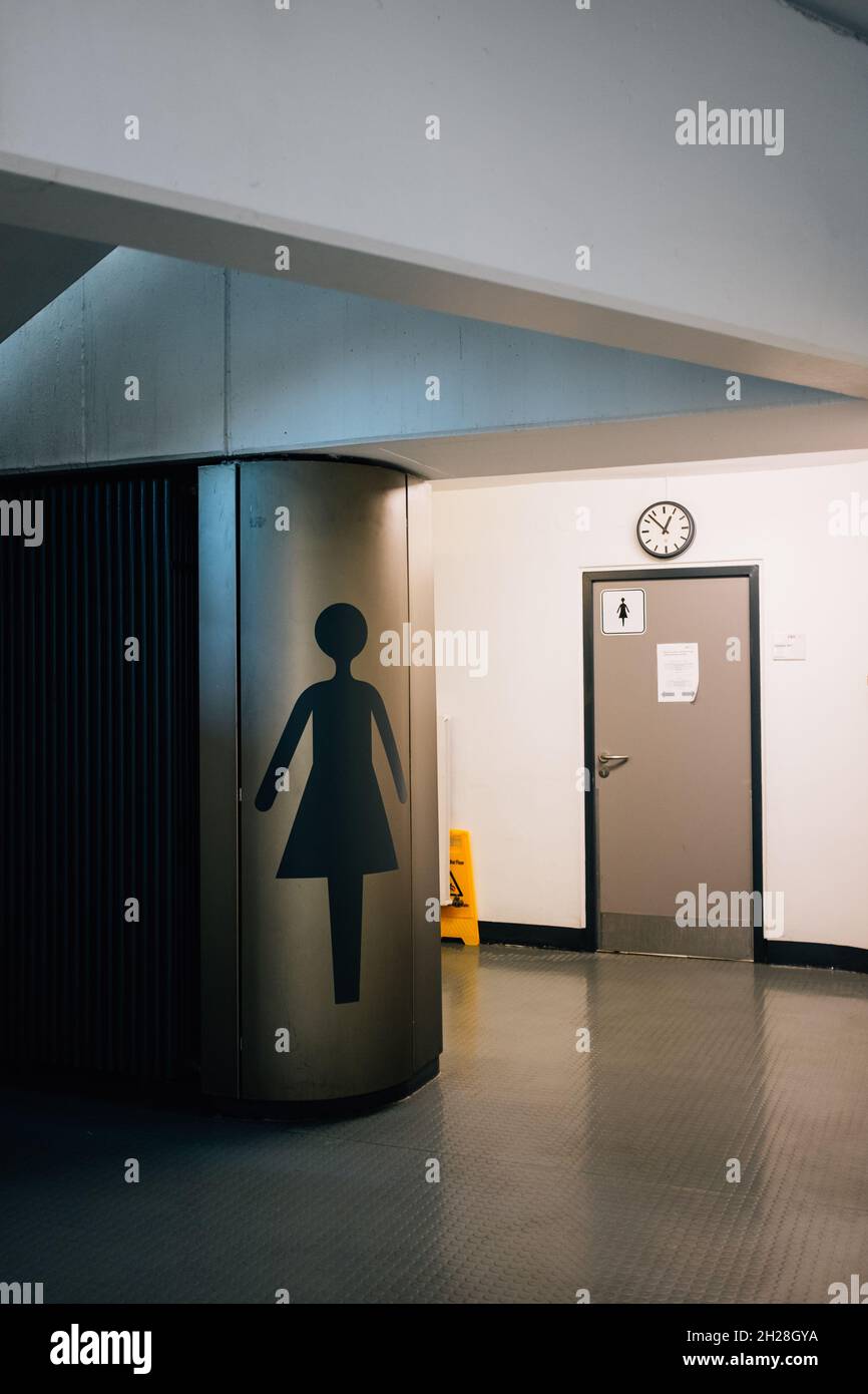 Vertical view of women restroom sign with a clock on the wall Stock ...