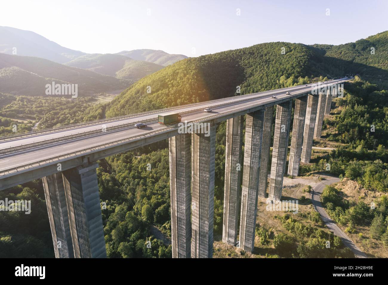 Aerial shot of a tall bridge and its traffic connecting the mountains ...