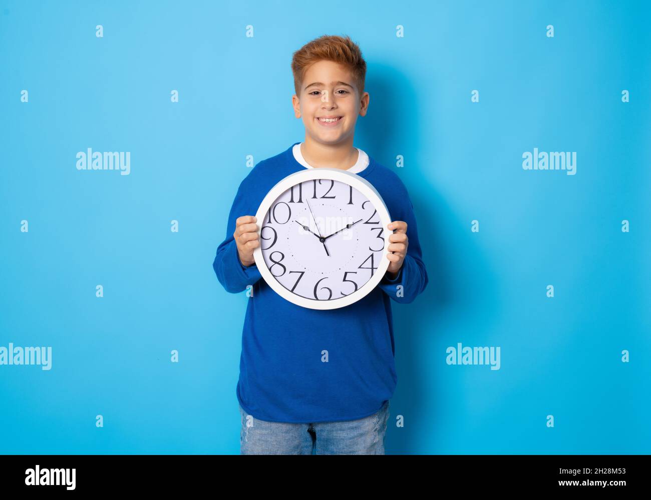 Portrait of caucasian boy with clock. Education and time concept Stock ...